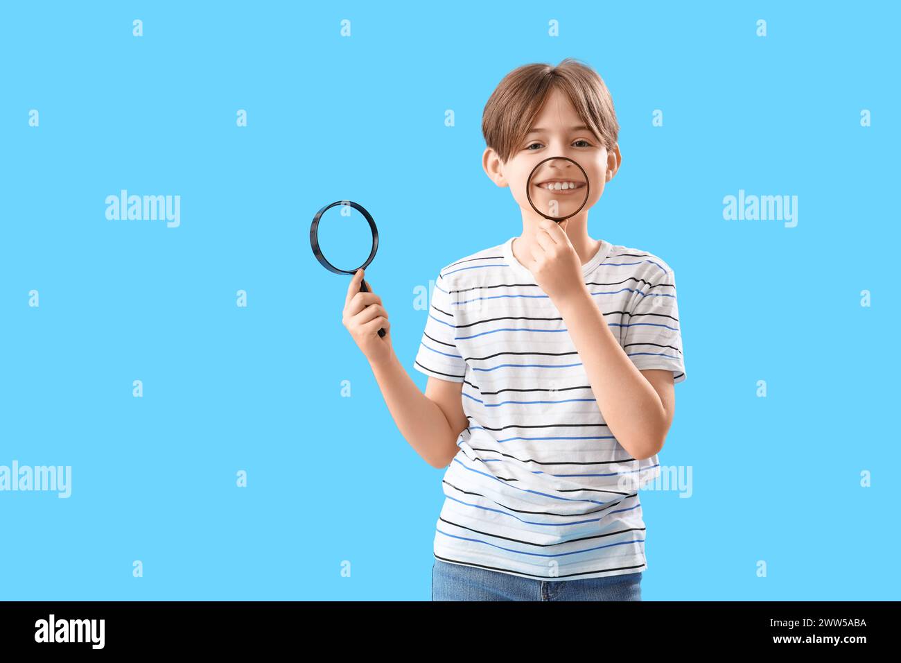 Little boy with magnifiers on blue background Stock Photo - Alamy