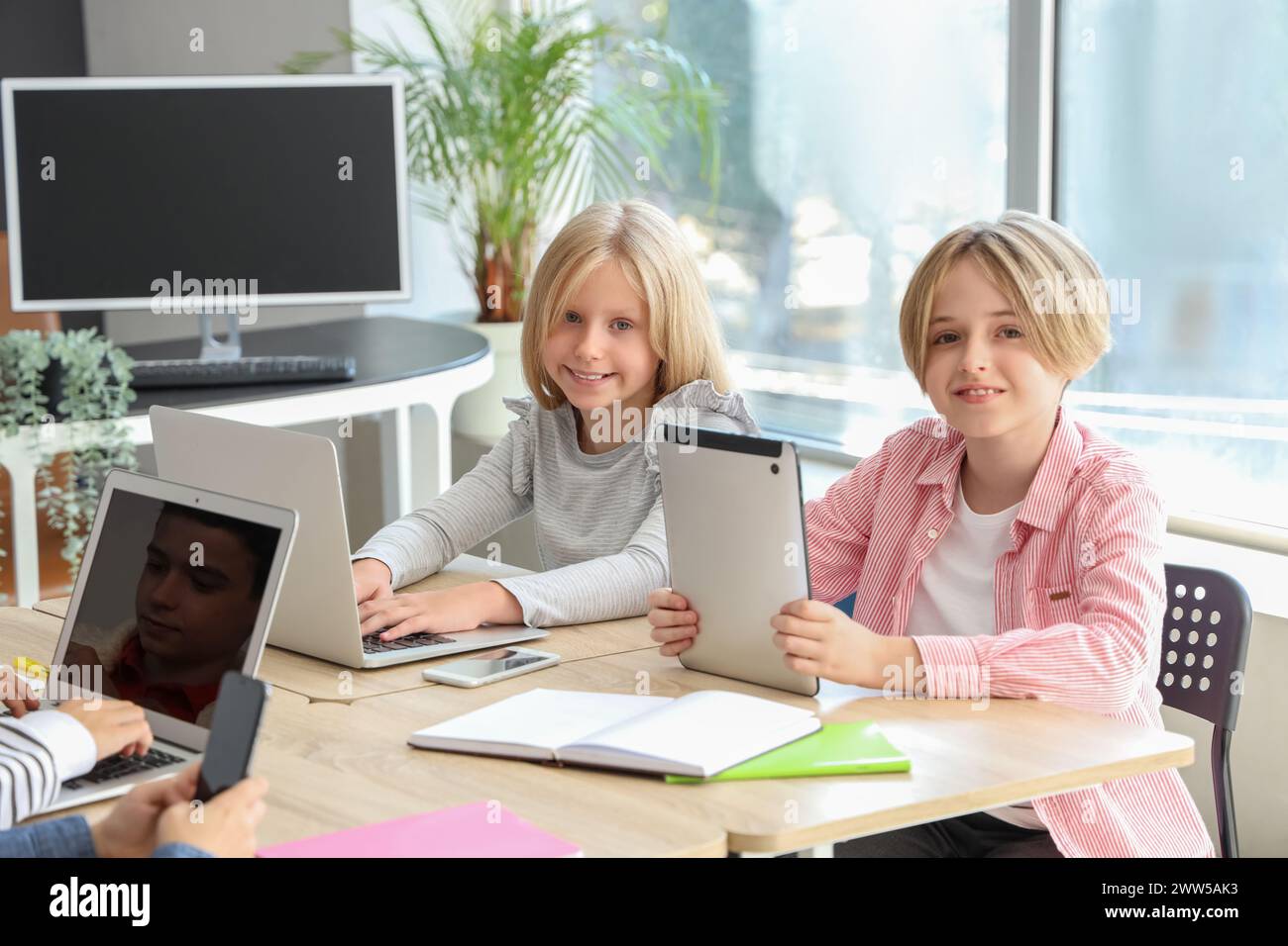 Little children studying with devices at school computer lab Stock ...