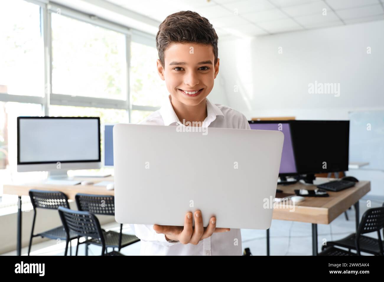 Little boy studying with laptop at school computer lab Stock Photo - Alamy