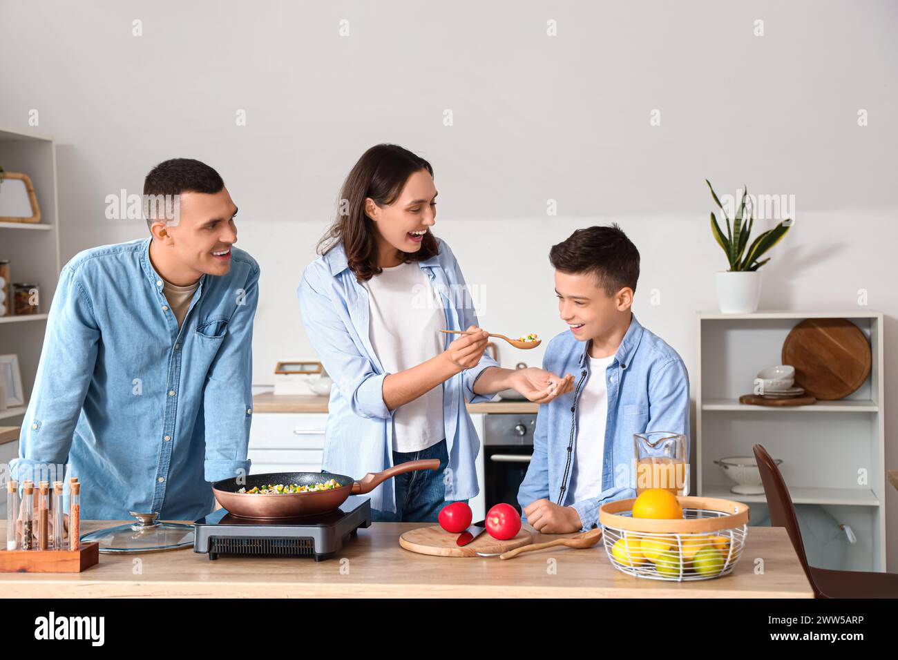 Little boy with his parents cooking at home Stock Photo - Alamy