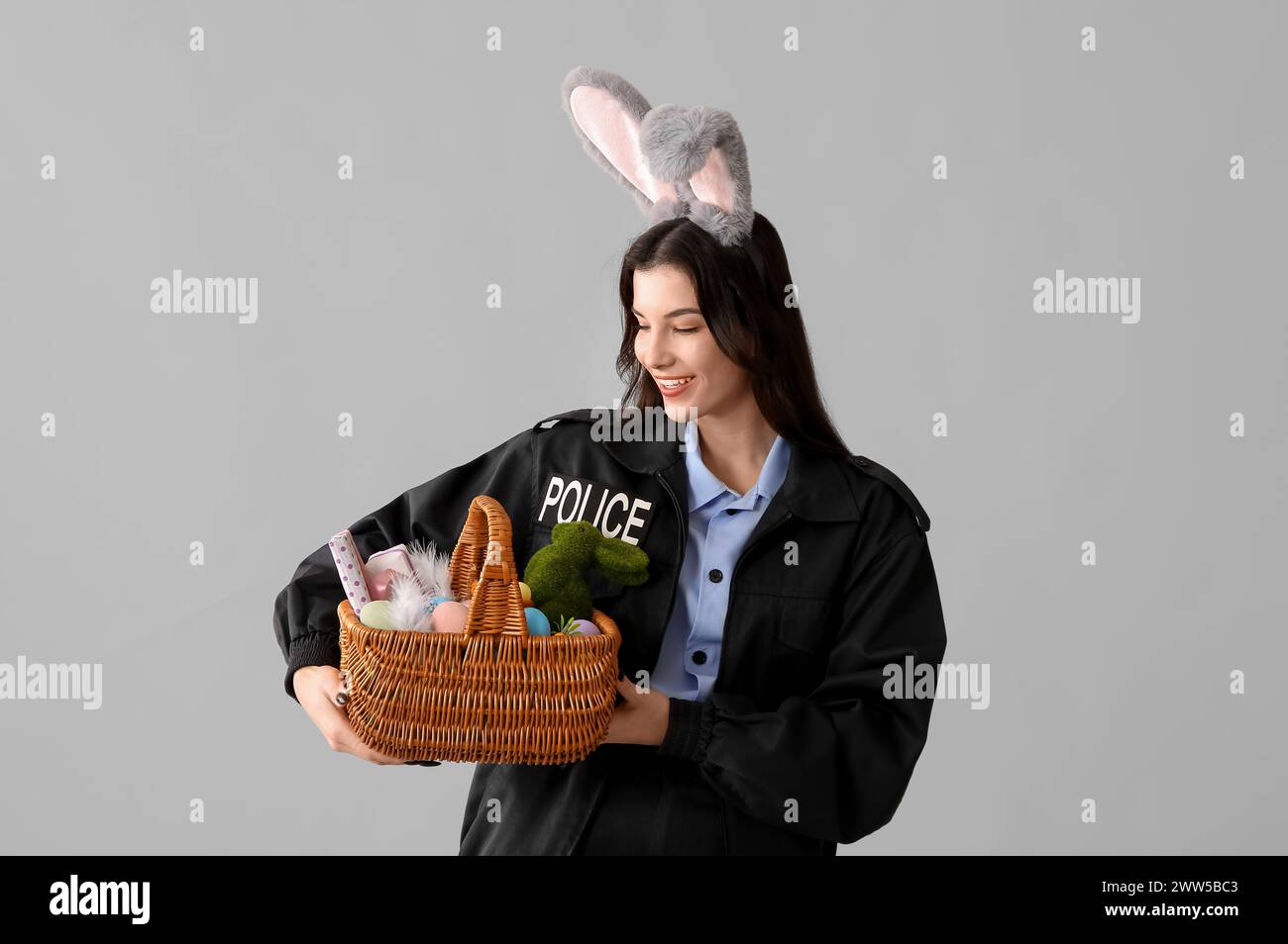 Female police officer in bunny ears with Easter eggs on light ...