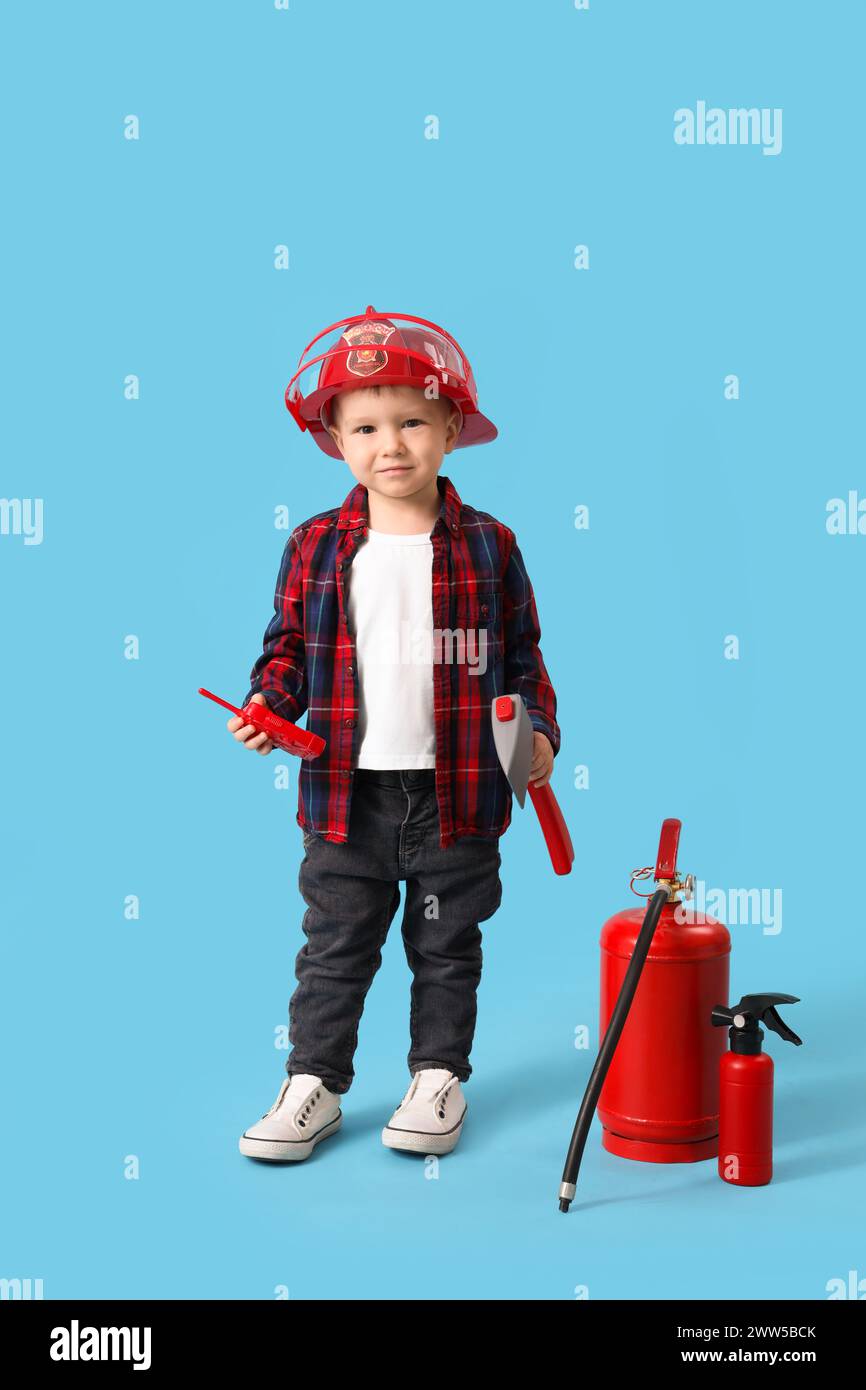Cute little fireman with walkie-talkie and fireaxe on blue background ...