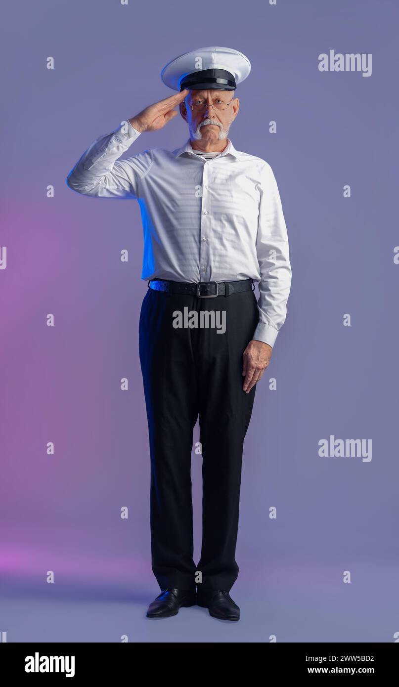 Mature sailor saluting on grey background Stock Photo - Alamy