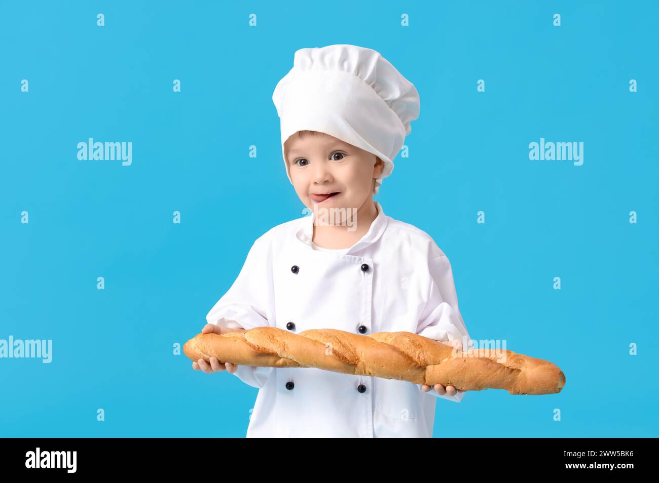 Cute little chef with baguette on blue background Stock Photo - Alamy