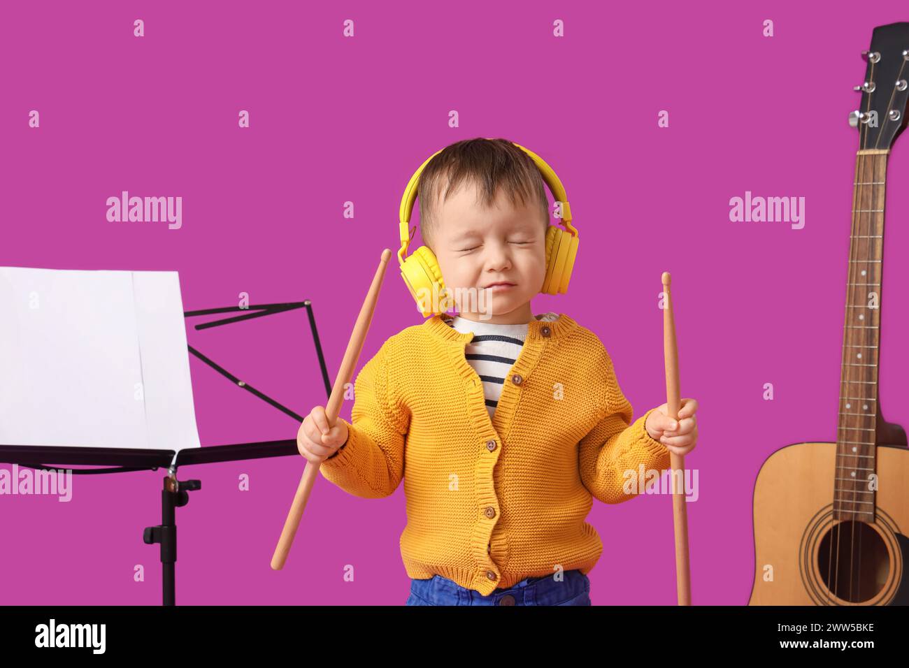 Cute little composer with drumsticks on pink background Stock Photo - Alamy