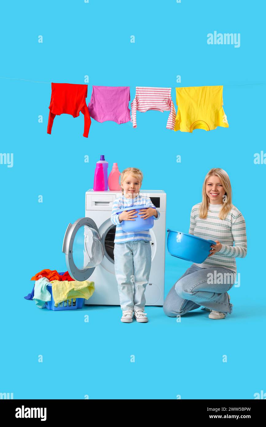 Happy mother and her little daughter doing laundry on blue background ...