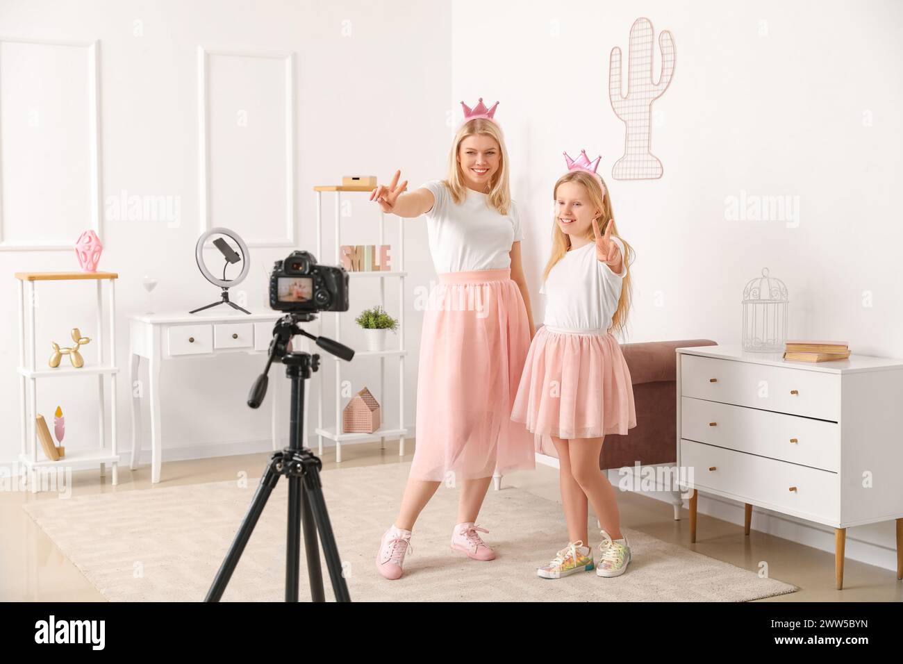 Beautiful female blogger with her daughter recording video at home ...