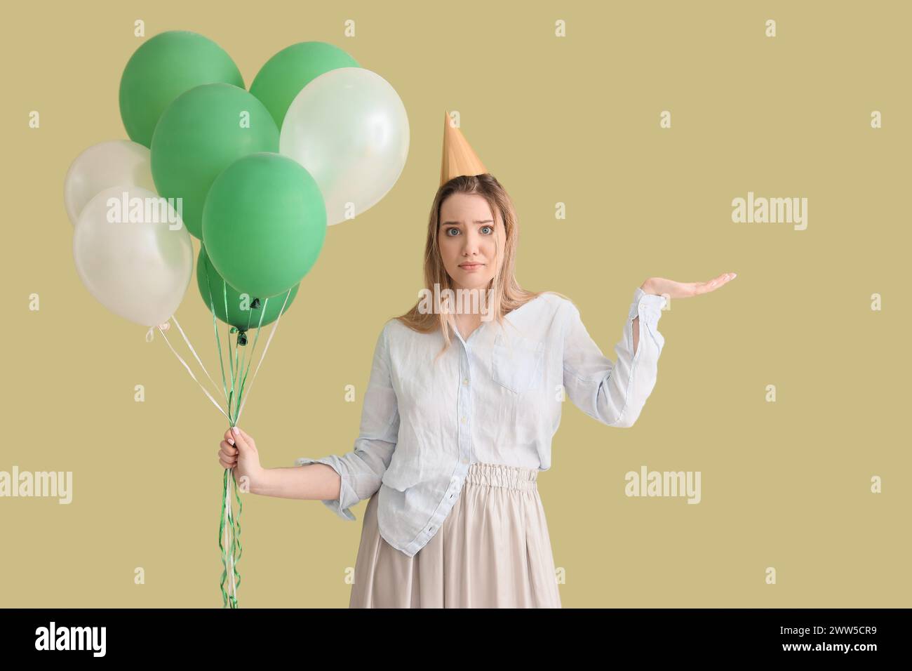 Confused young woman with hangover and balloons after Birthday party on ...