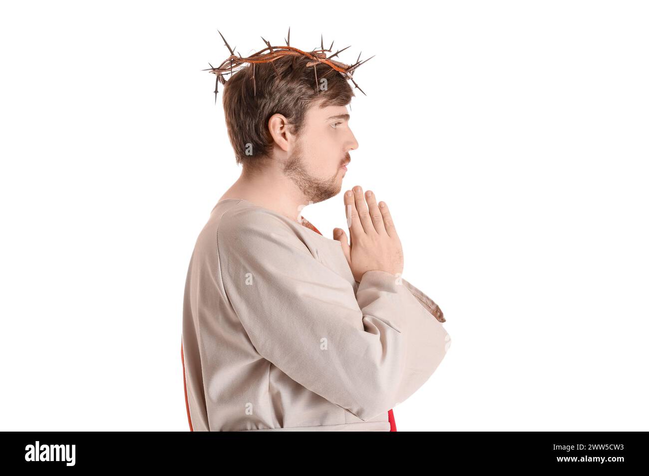 Man in Jesus robe and crown of thorns praying on white background Stock ...
