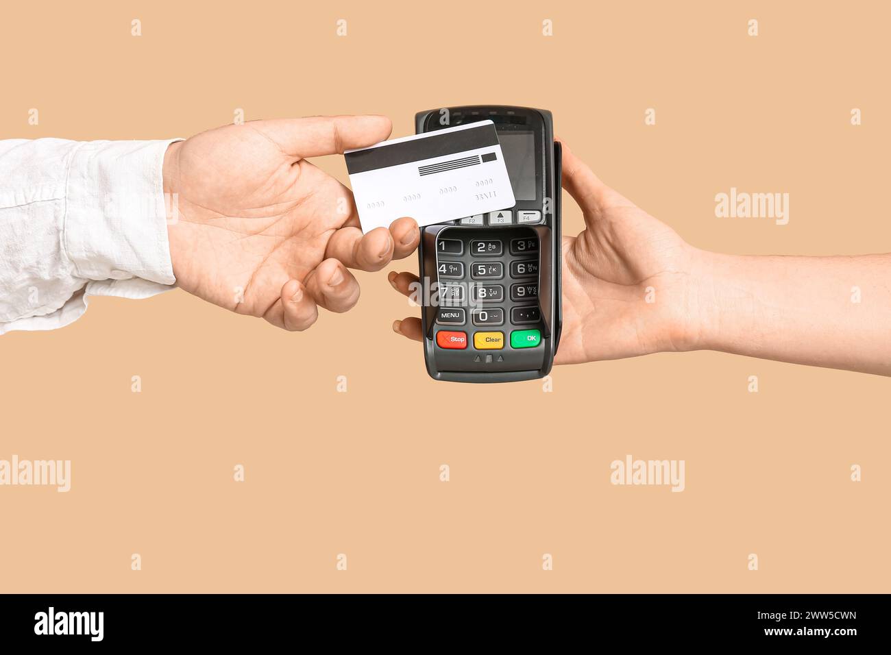 Male hand with credit card and payment terminal on beige background ...