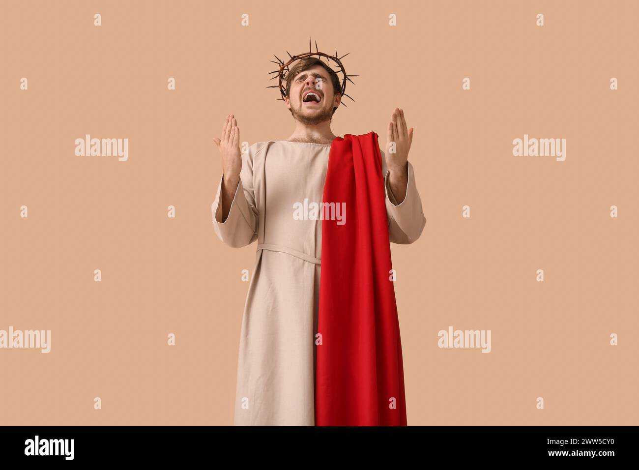 Man in Jesus robe and crown of thorns with outstretched hands screaming ...