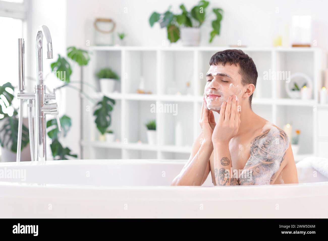 Handsome man taking bath with foam at home Stock Photo - Alamy
