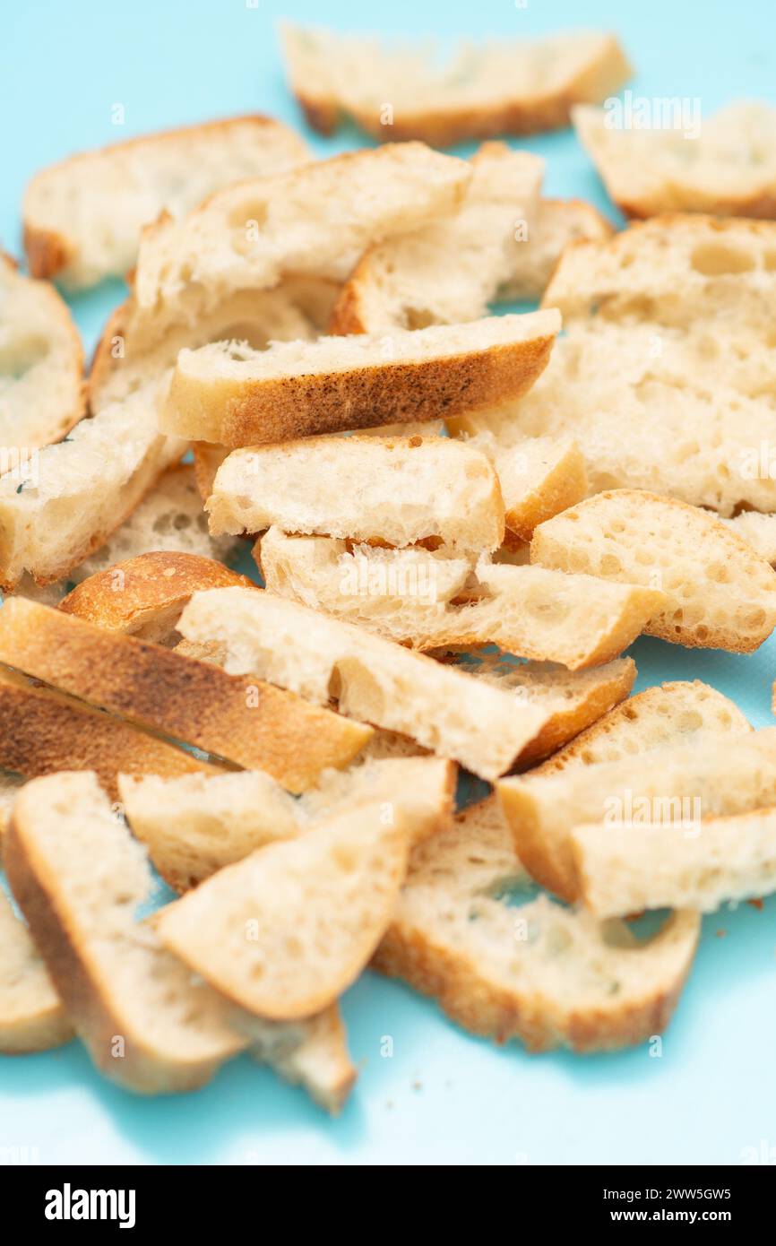 A pile of bread crumbs on a blue background. The crumbs are scattered ...