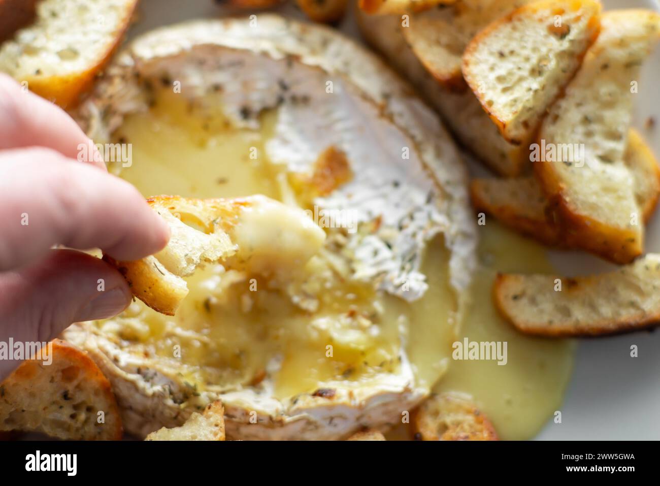 A person is eating a piece of bread with a dip Stock Photo - Alamy