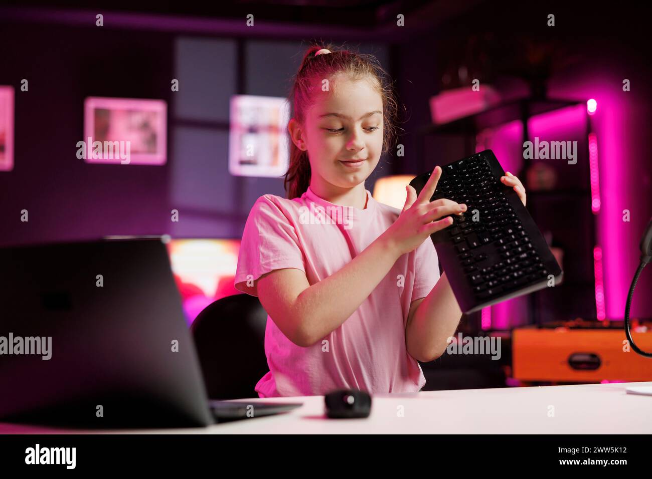 Happy charismatic girl presenting latest gaming computer peripheral ...