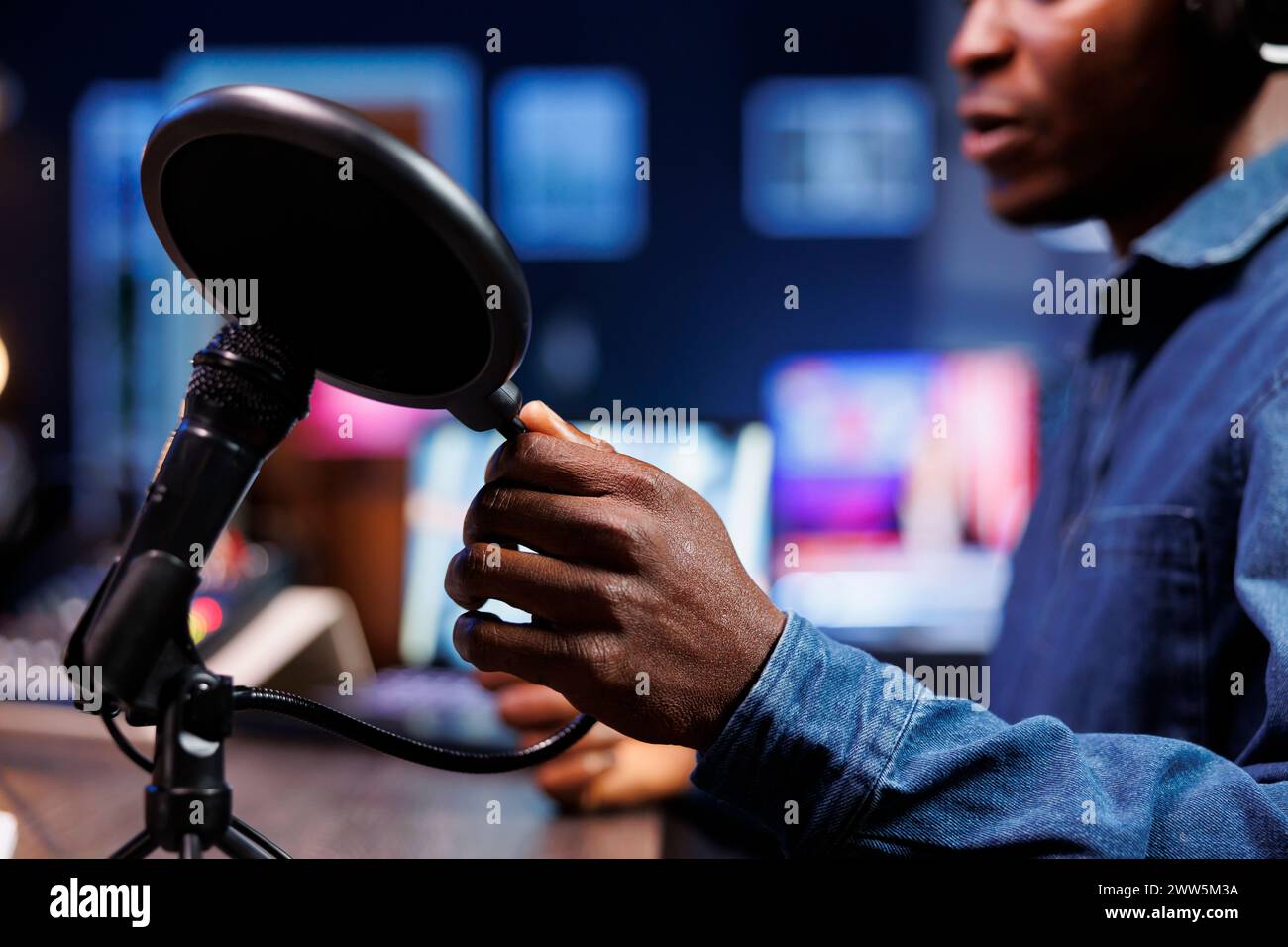 Black man uses professional mic to record a podcast in home studio ...