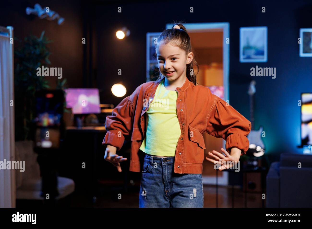 Young gen Z content creator in dimly lit home studio dances for online ...