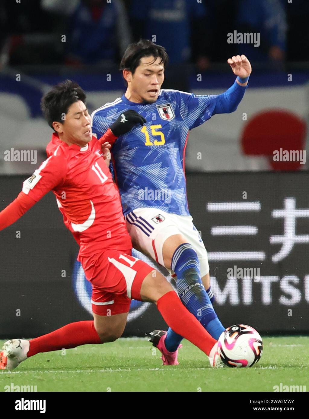 Tokyo, Japan. 21st Mar, 2024. Japan's Koki Machida (R) fights the ball ...