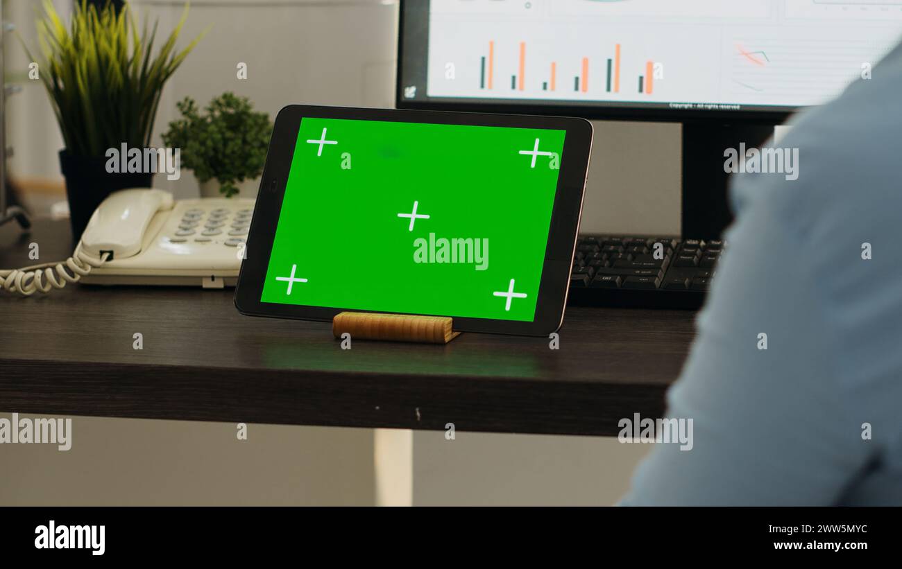 Woman works at office desk and uses modern gadget to present ...