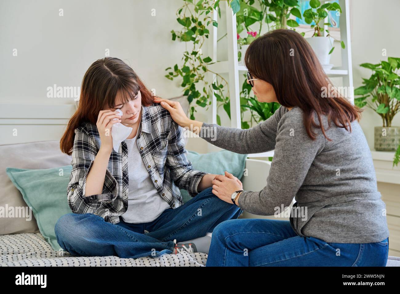 Upset sad crying daughter teenager sitting together with mother on ...