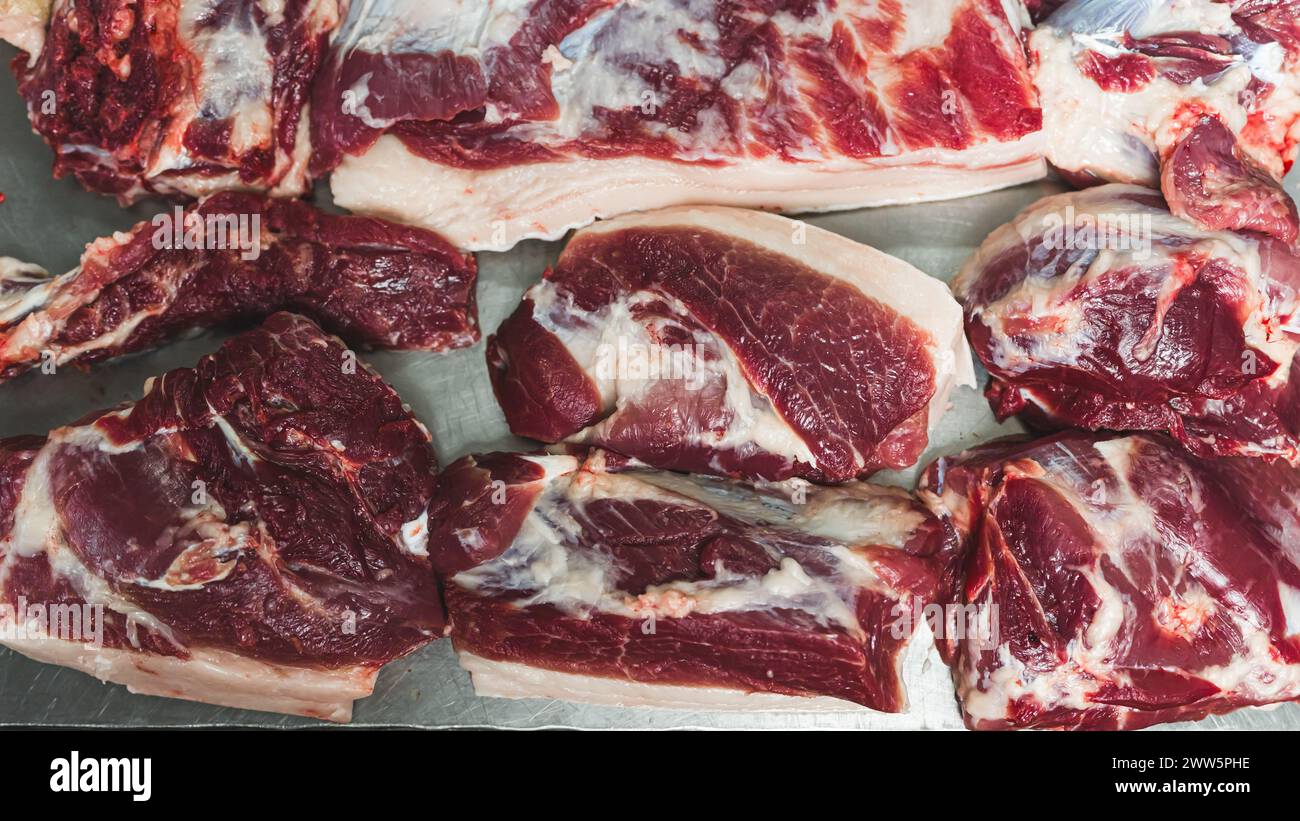 Close-up of raw meat cutting with a knife in an abattoir doing ...