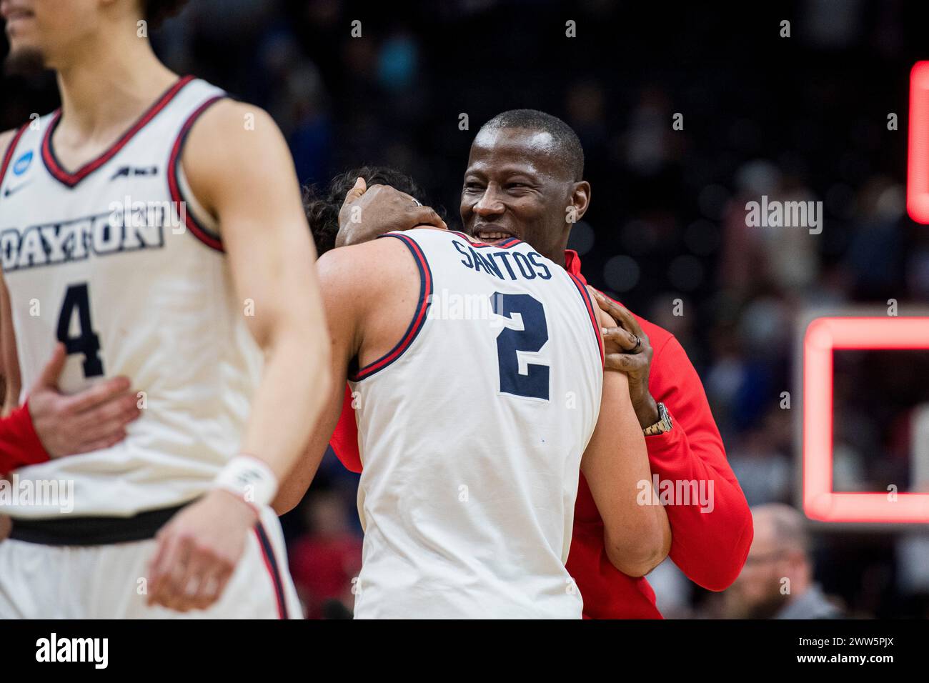 Dayton head coach Anthony Grant, right, hugs Dayton forward Nate Santos ...