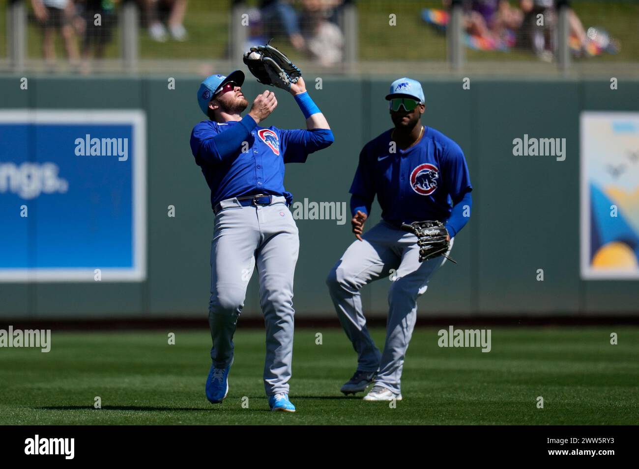 Chicago Cubs left fielder Ian Happ, left, makes a catch on a fly ball ...