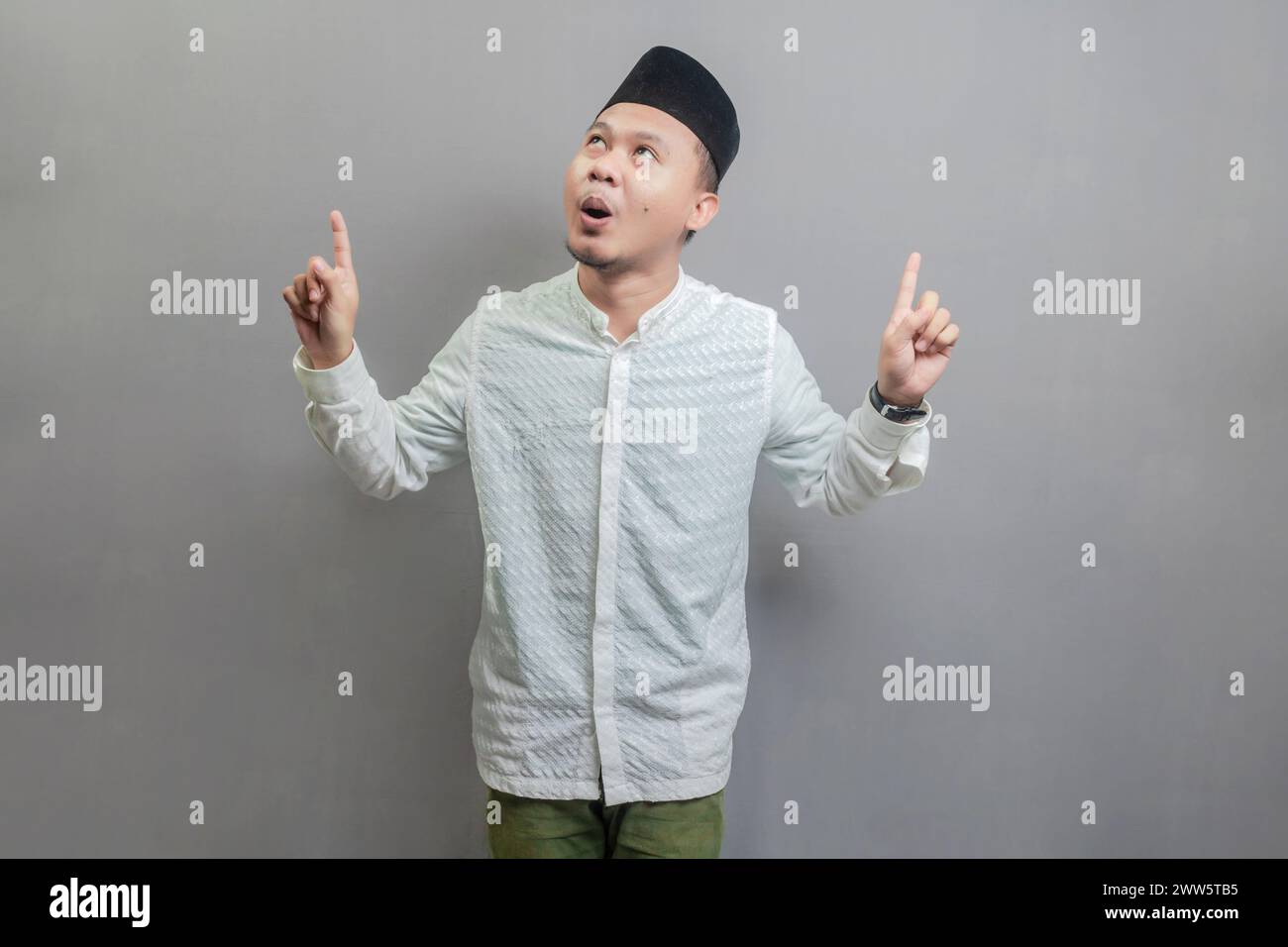 Happy asian muslim man recommend promo as pointing to copy space ...