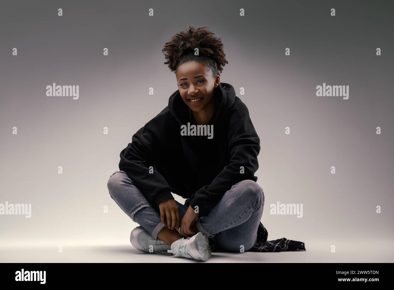 woman’s easy smile and relaxed seated position convey a moment of ...