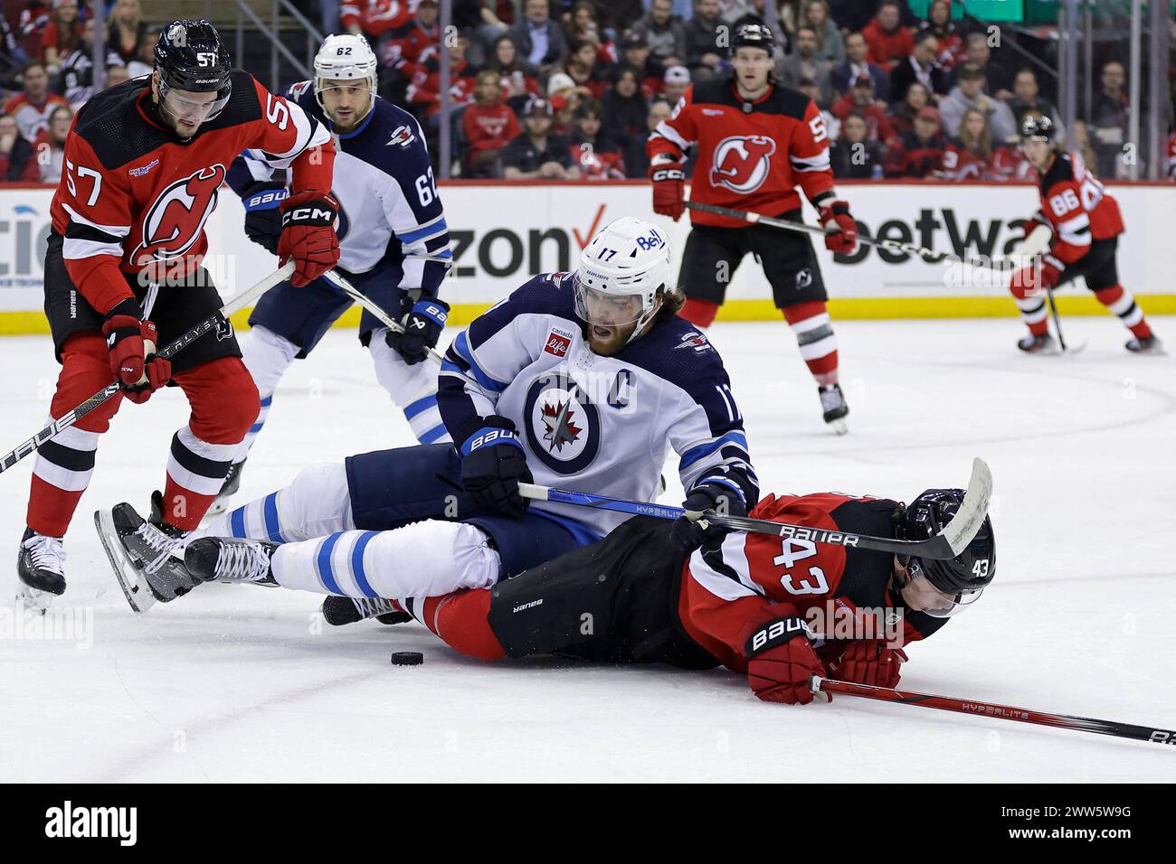 Winnipeg Jets center Adam Lowry (17) falls onto New Jersey Devils ...