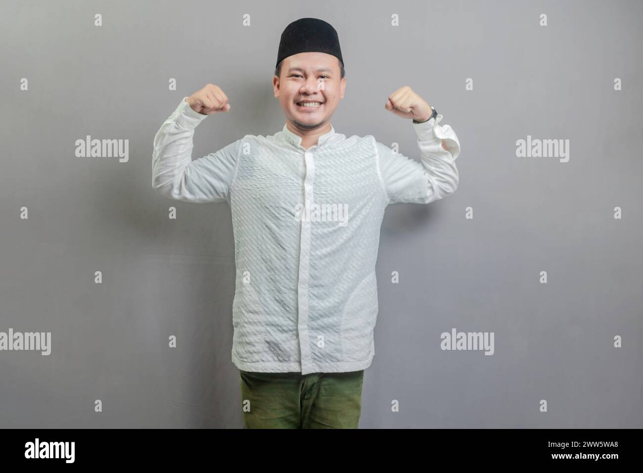 Happy asian muslim man fun successful raised hands show muscles wearing ...