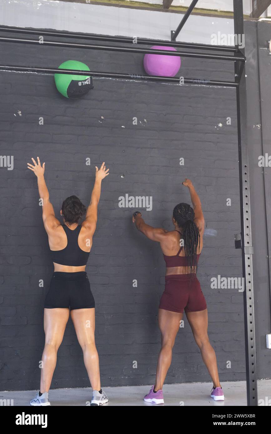 Two fit women are performing wall ball exercises in a gym Stock Photo ...