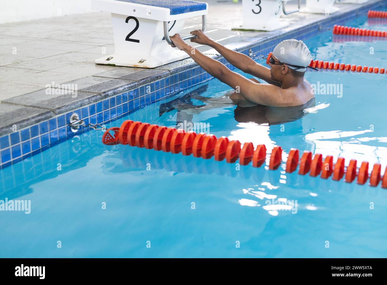 A fit African American male athlete swimmer is preparing to swim Stock ...