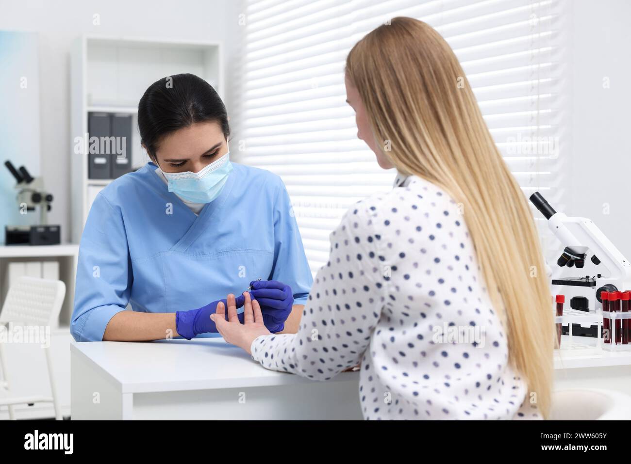 Laboratory testing. Doctor taking blood sample from patient at white ...
