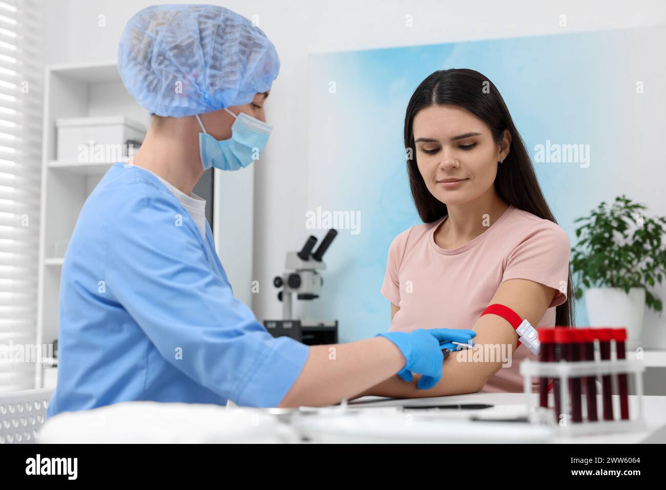 Laboratory testing. Doctor taking blood sample from patient at white ...