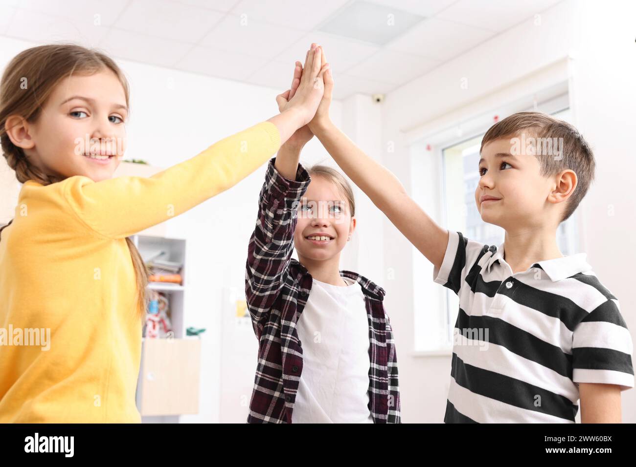 Happy children giving high five at school Stock Photo - Alamy