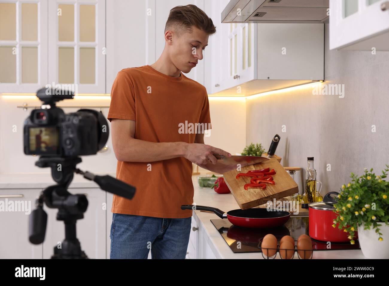 Food blogger cooking while recording video in kitchen Stock Photo - Alamy