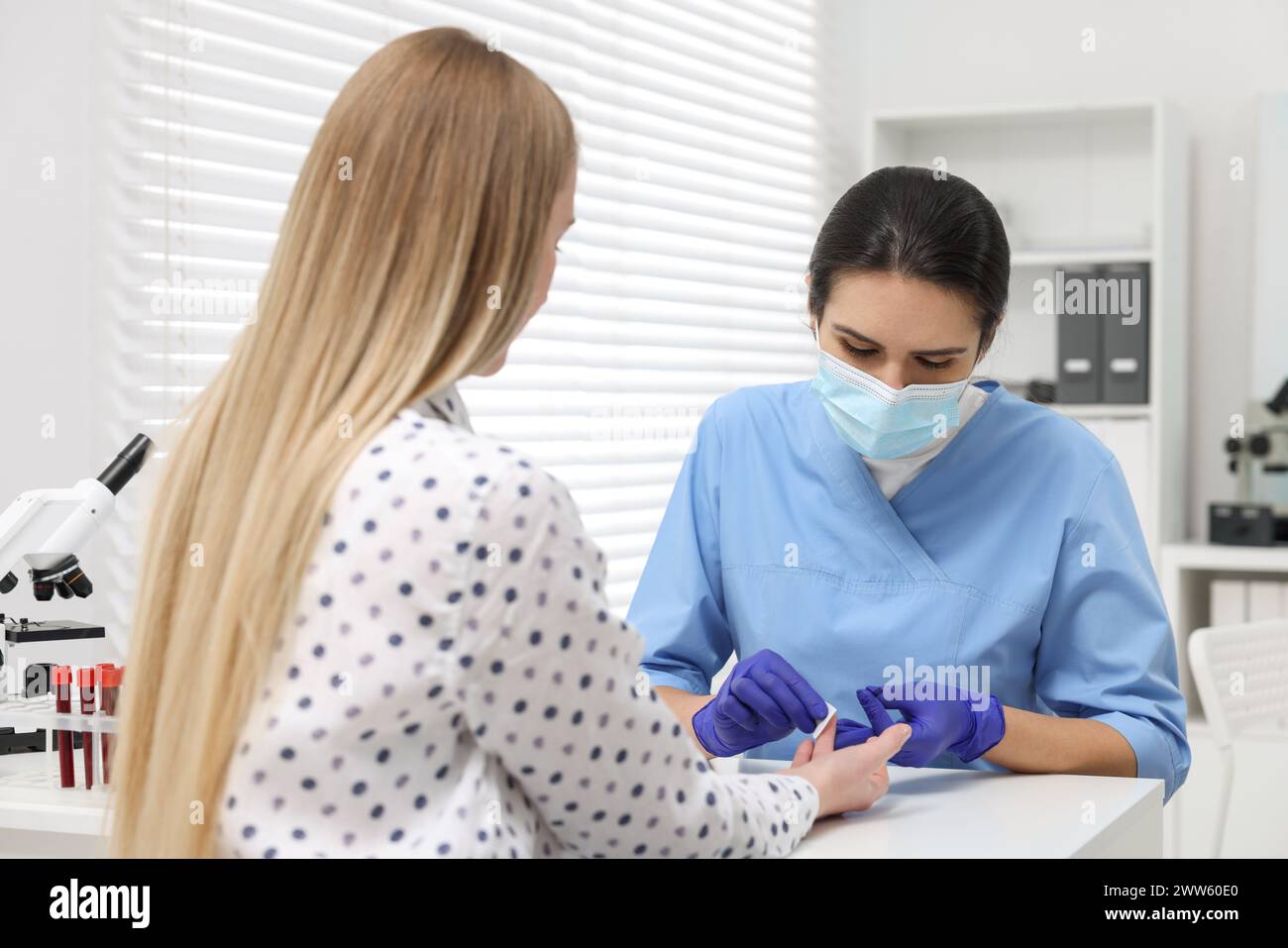 Laboratory testing. Doctor taking blood sample from patient at white ...