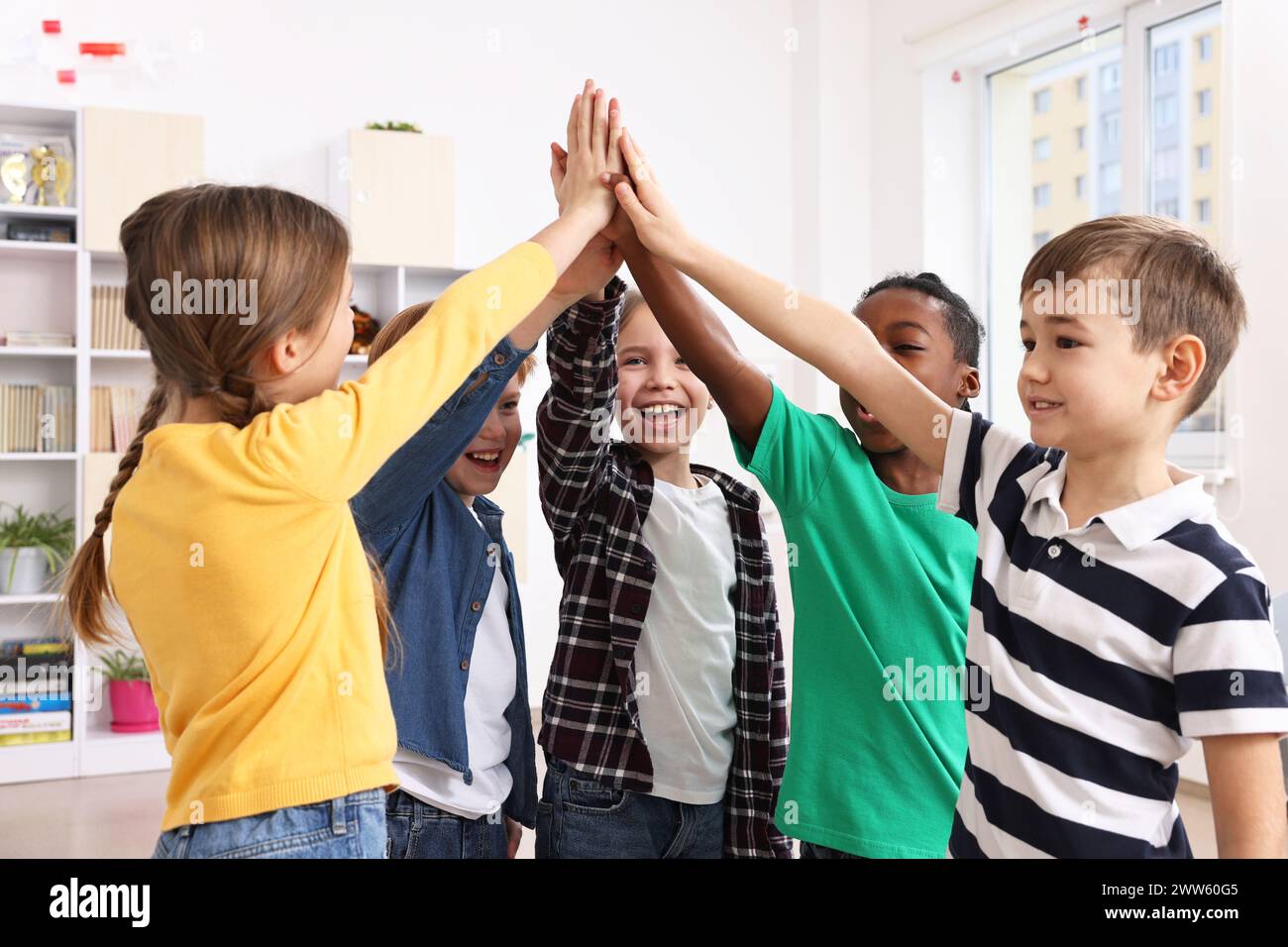 Happy children giving high five at school Stock Photo - Alamy