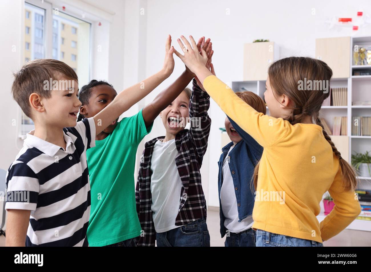 Happy children giving high five at school Stock Photo - Alamy