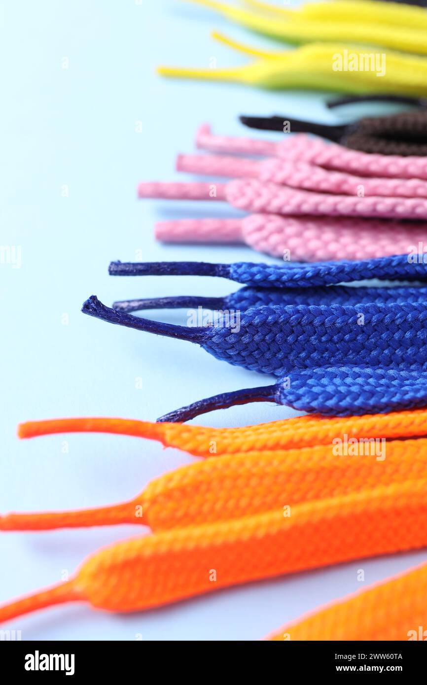 Many colorful shoe laces on light blue background, closeup Stock Photo ...