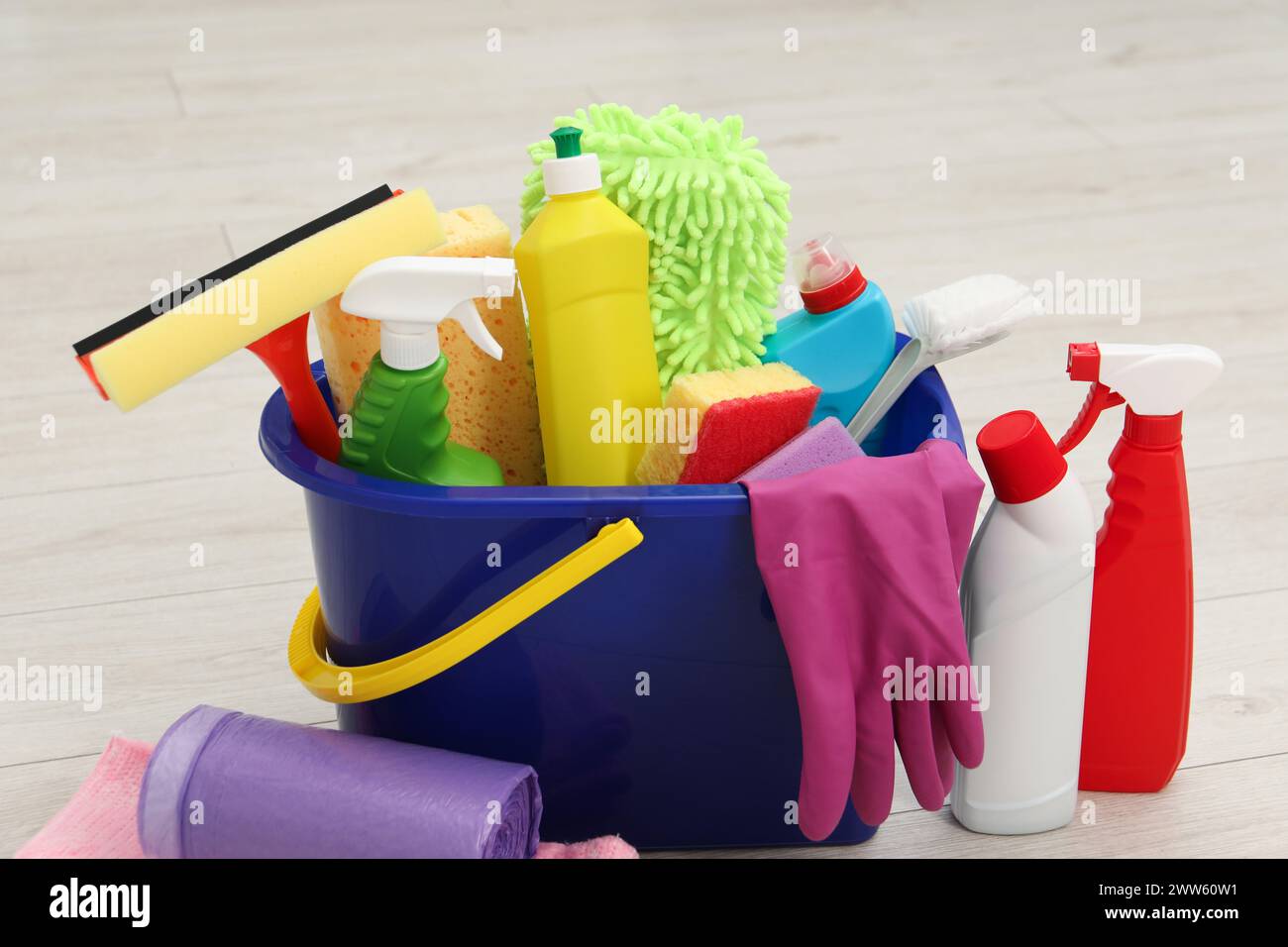 Different cleaning supplies in bucket on floor Stock Photo - Alamy