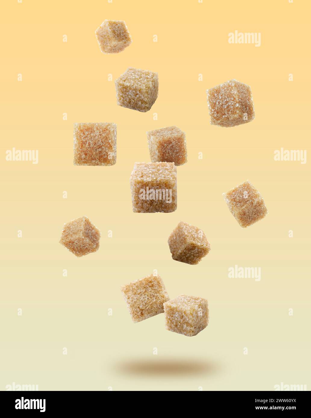Brown cane sugar cubes falling on golden gradient background Stock ...
