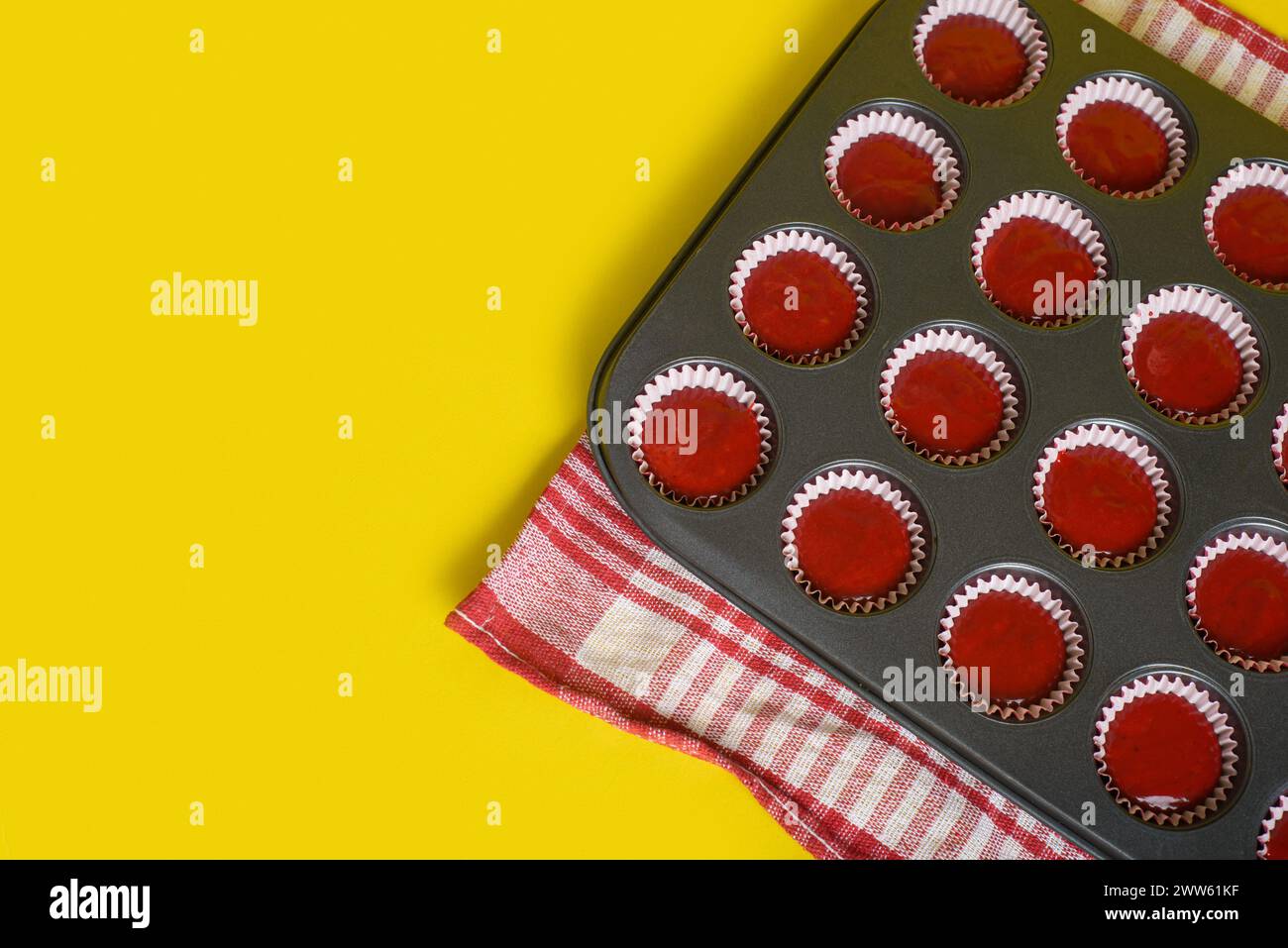 Tray with mix of red velvet cupcake ingredients ready to bake. Yellow ...