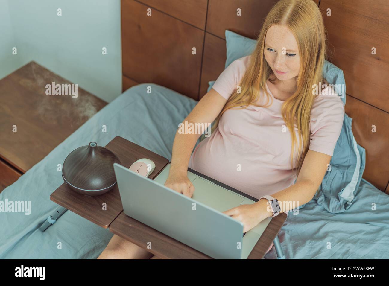 Multitasking expectant woman enhances her home workspace, using an ...
