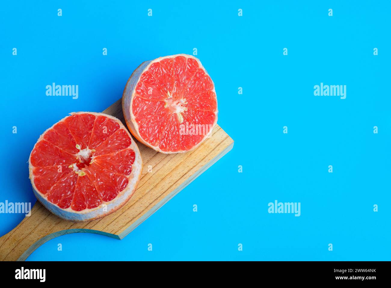 Cut pink grapefruit isolated on blue background. Citrus isolated Stock ...