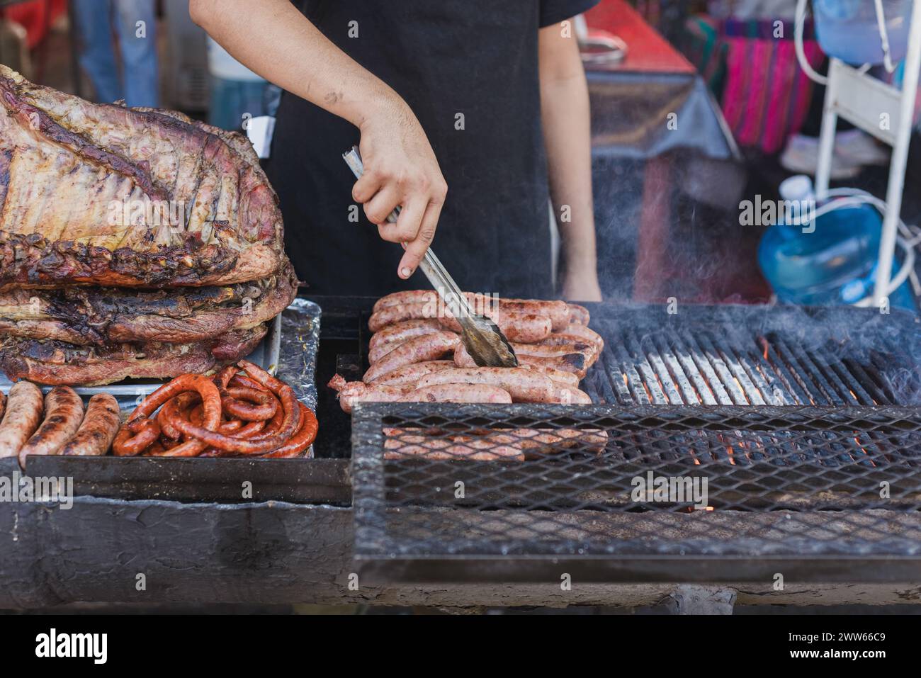 Person grilling meat on a rustic grill in Mexico. Street stall of ...