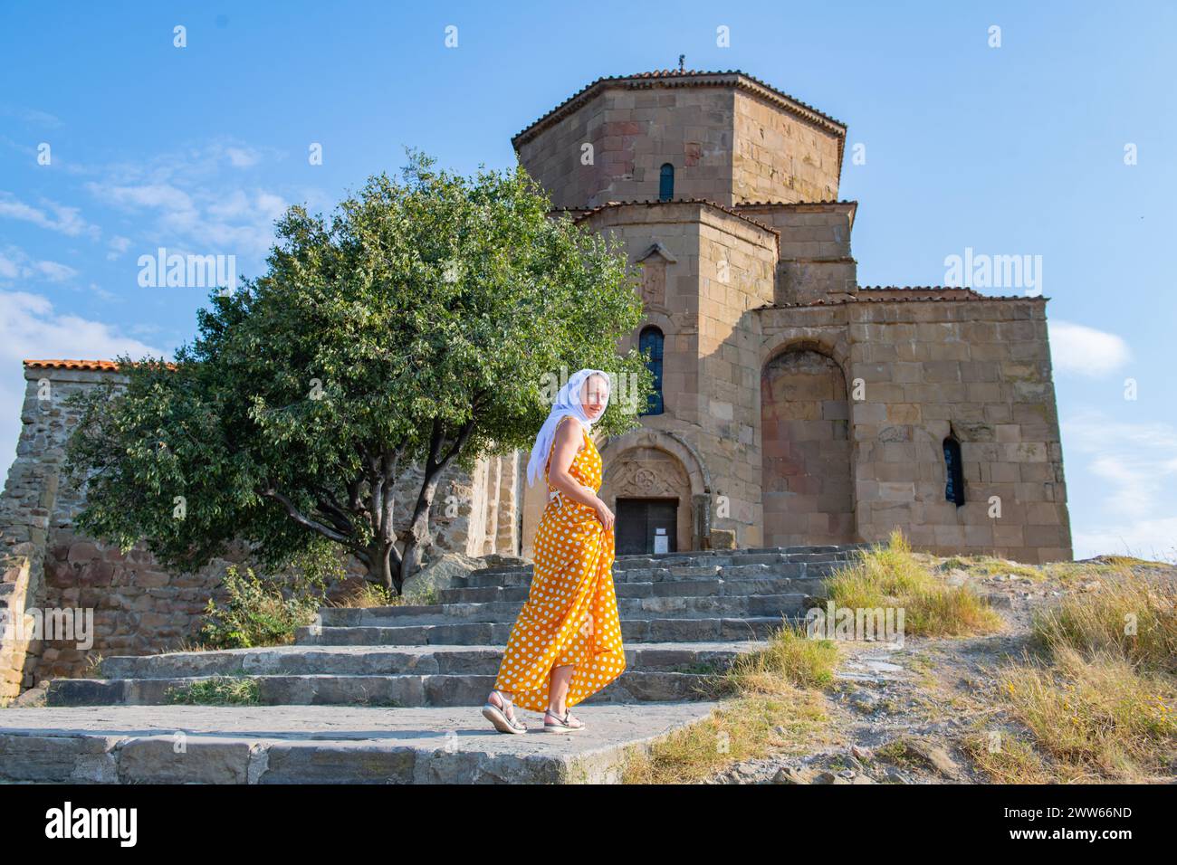 Lady in Orange Dress and White Scarf Posing by Traditional Old Church ...