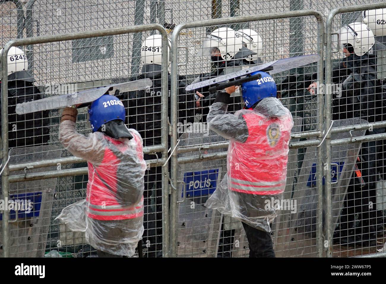 Two Turkish policemen are seen trying to protect themselves from stones ...