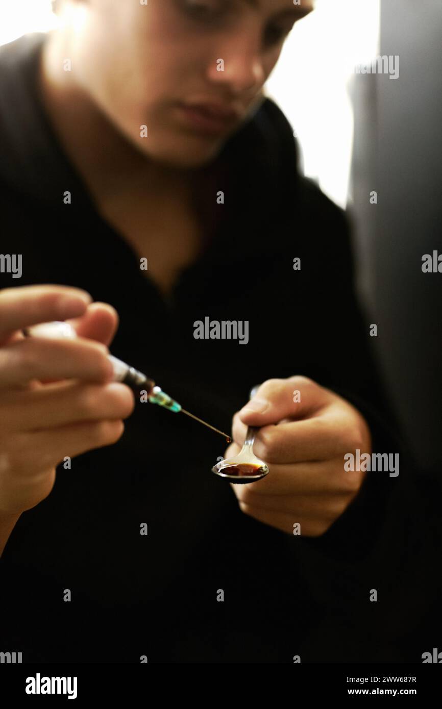 Man, syringe and spoon for heroin drug as unhealthy addiction or mental ...